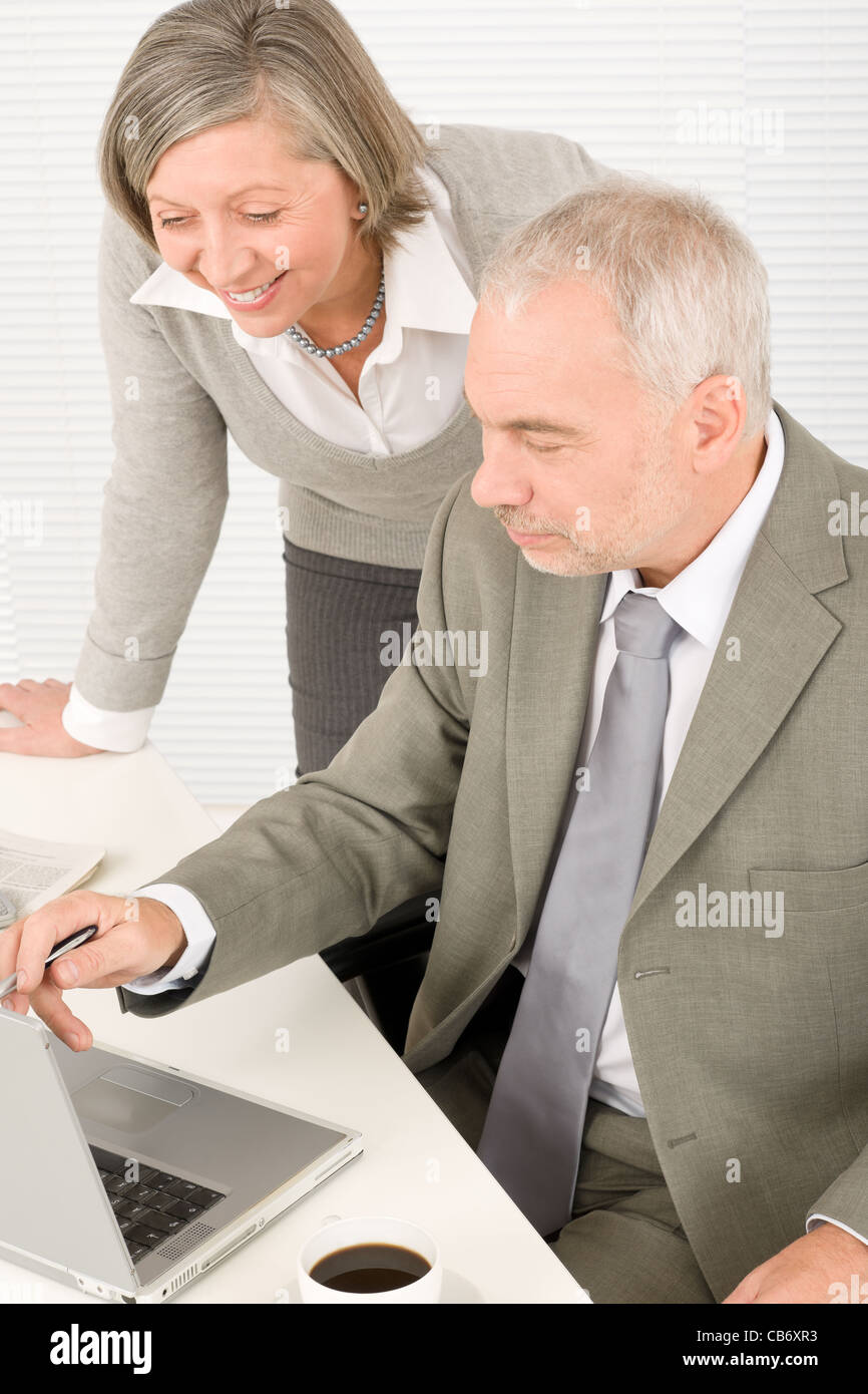 Professional businesspeople behind office table with laptop Stock Photo ...