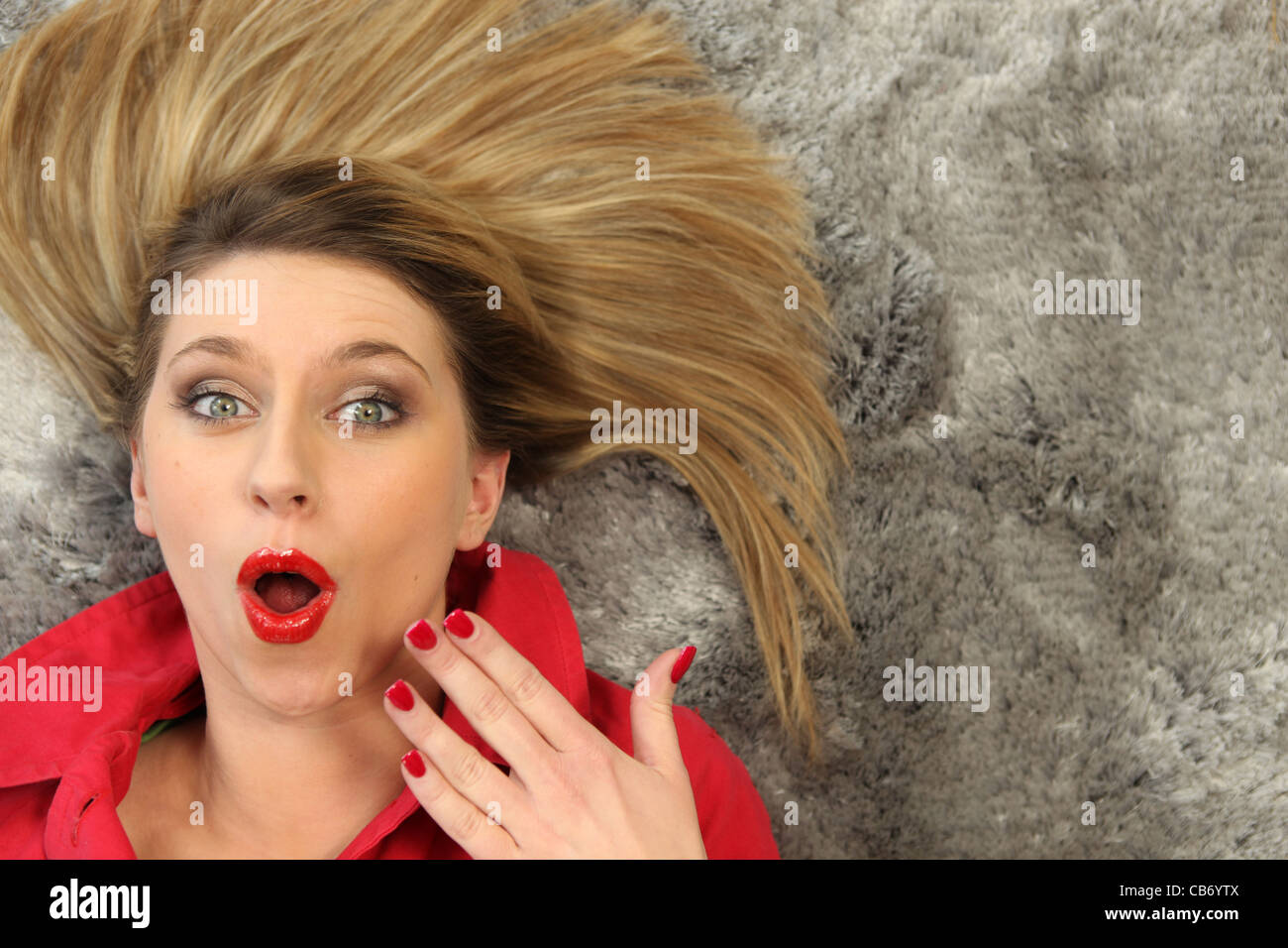 Vivacious woman lying on a rug Stock Photo - Alamy