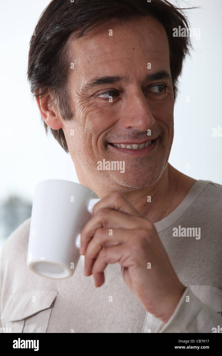 Man smiling with a cup of tea Stock Photo - Alamy