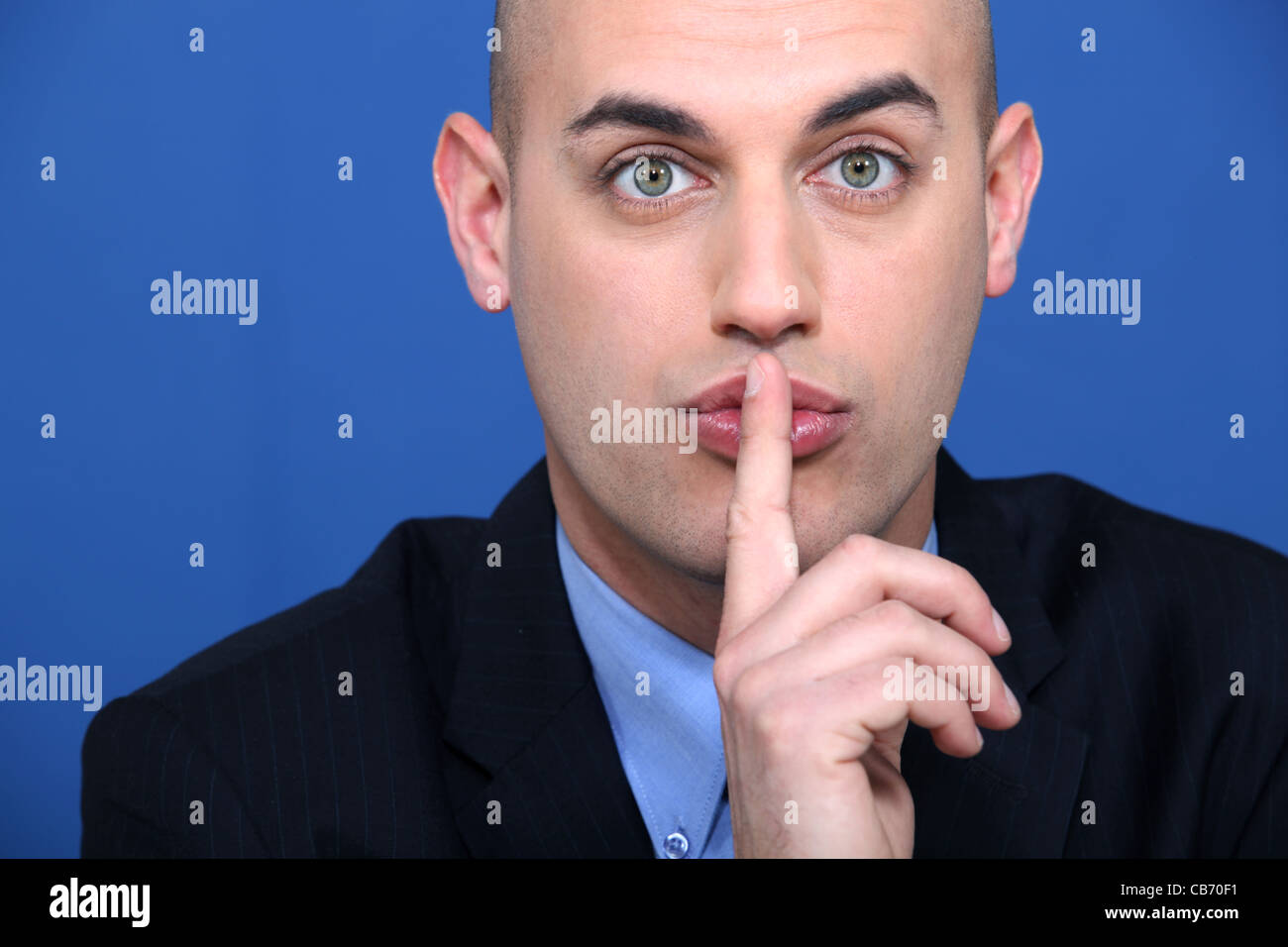 Bald businessman making shush gesture Stock Photo - Alamy