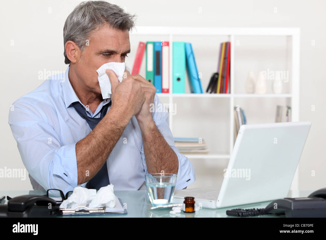 Office worker suffering from a cold Stock Photo - Alamy