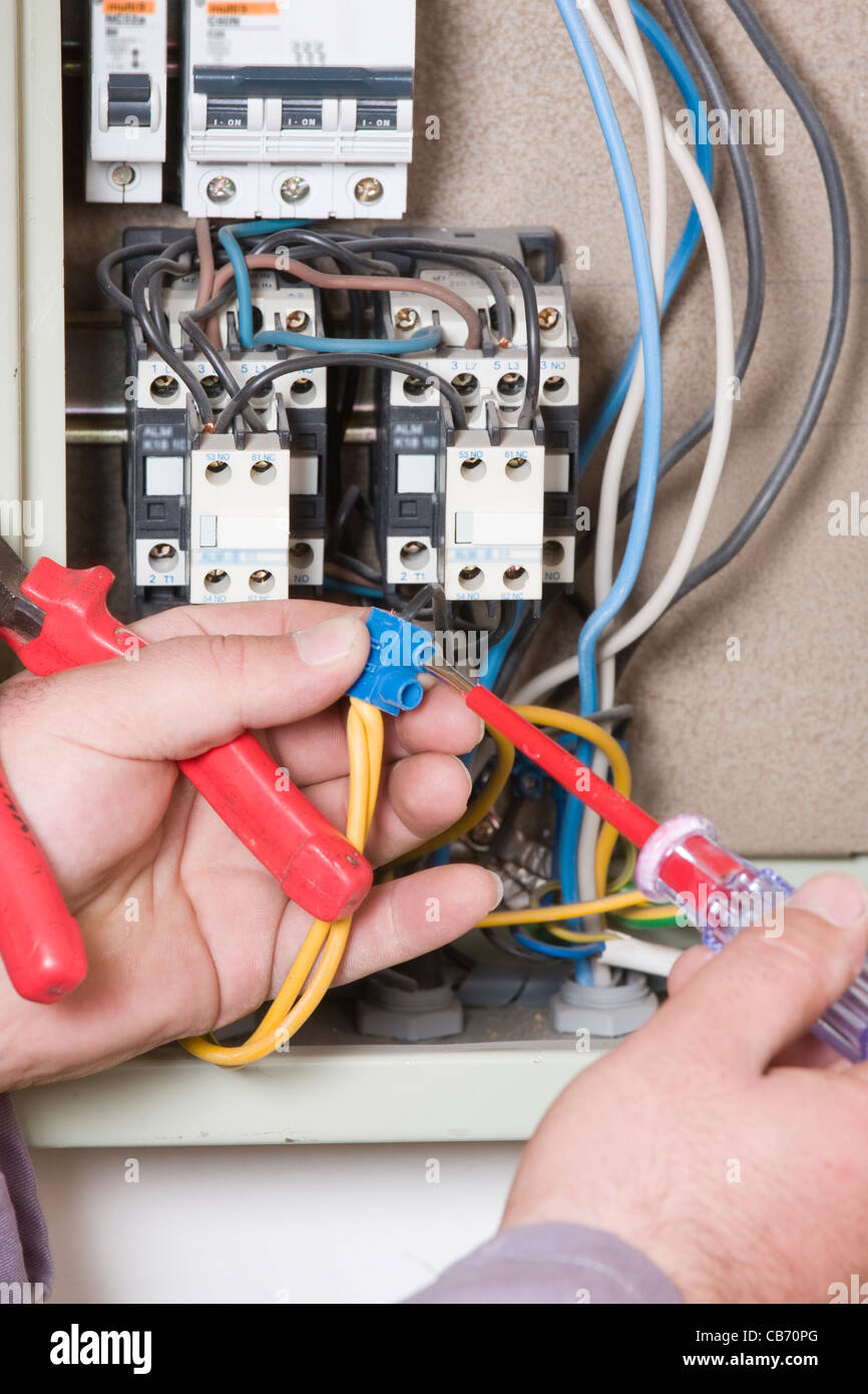 Electrician working on a panel Stock Photo - Alamy