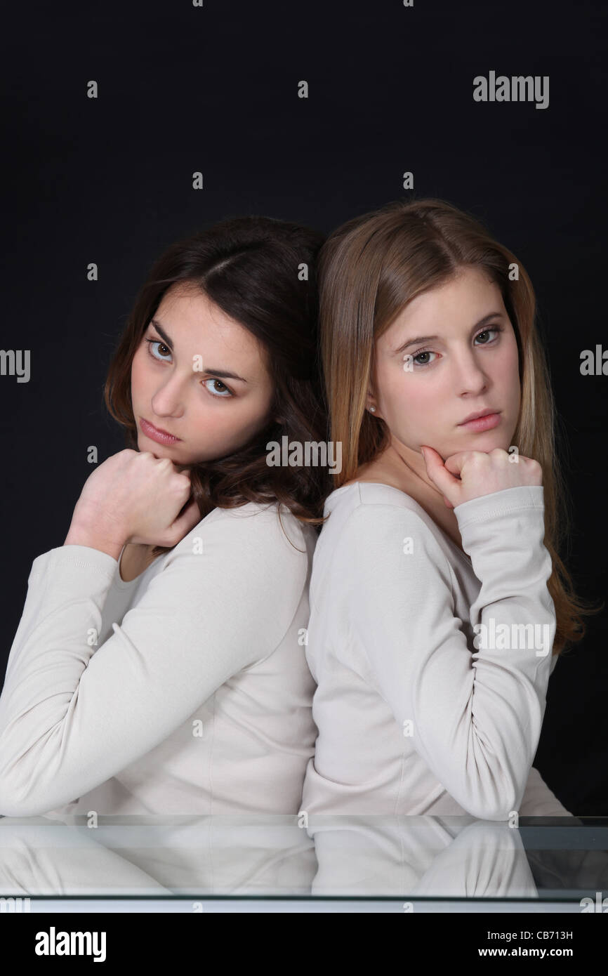 girls sitting back to back Stock Photo - Alamy