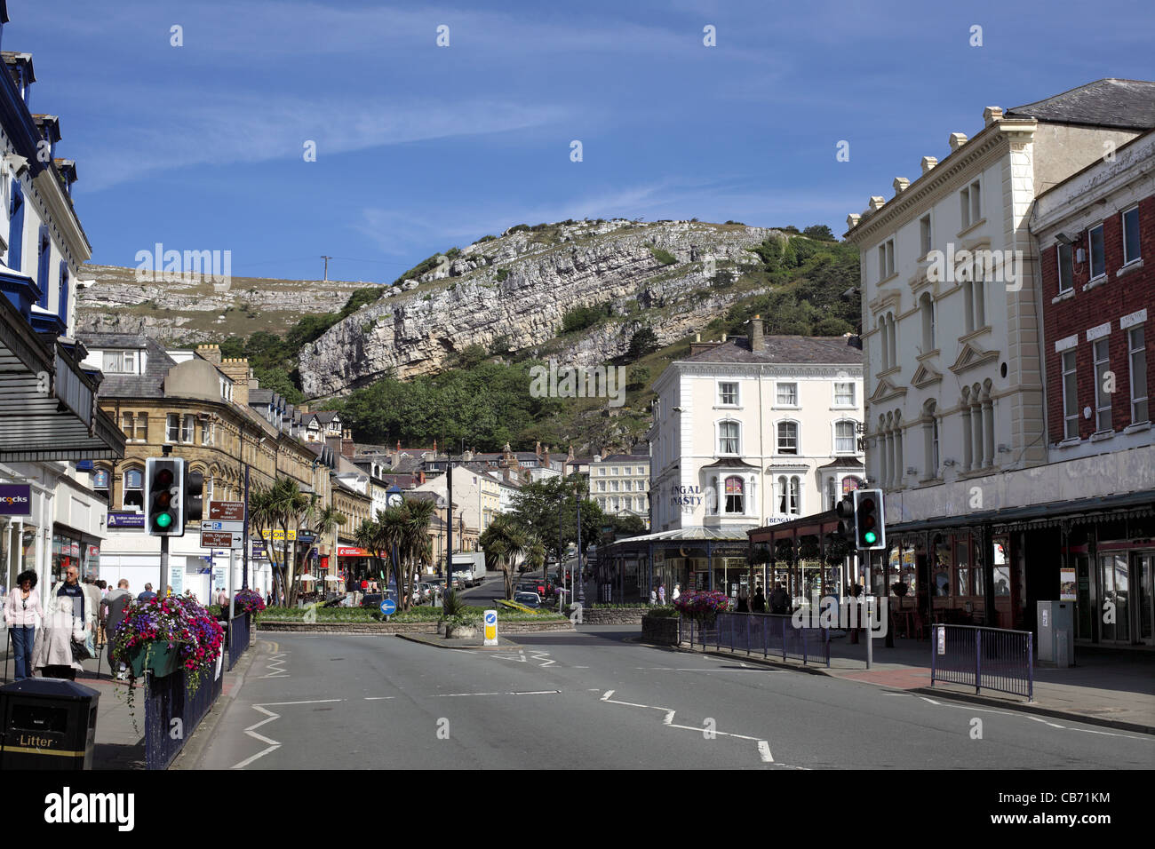 Inclined strata of limestone on the Great Orme rising behind Mostyn ...