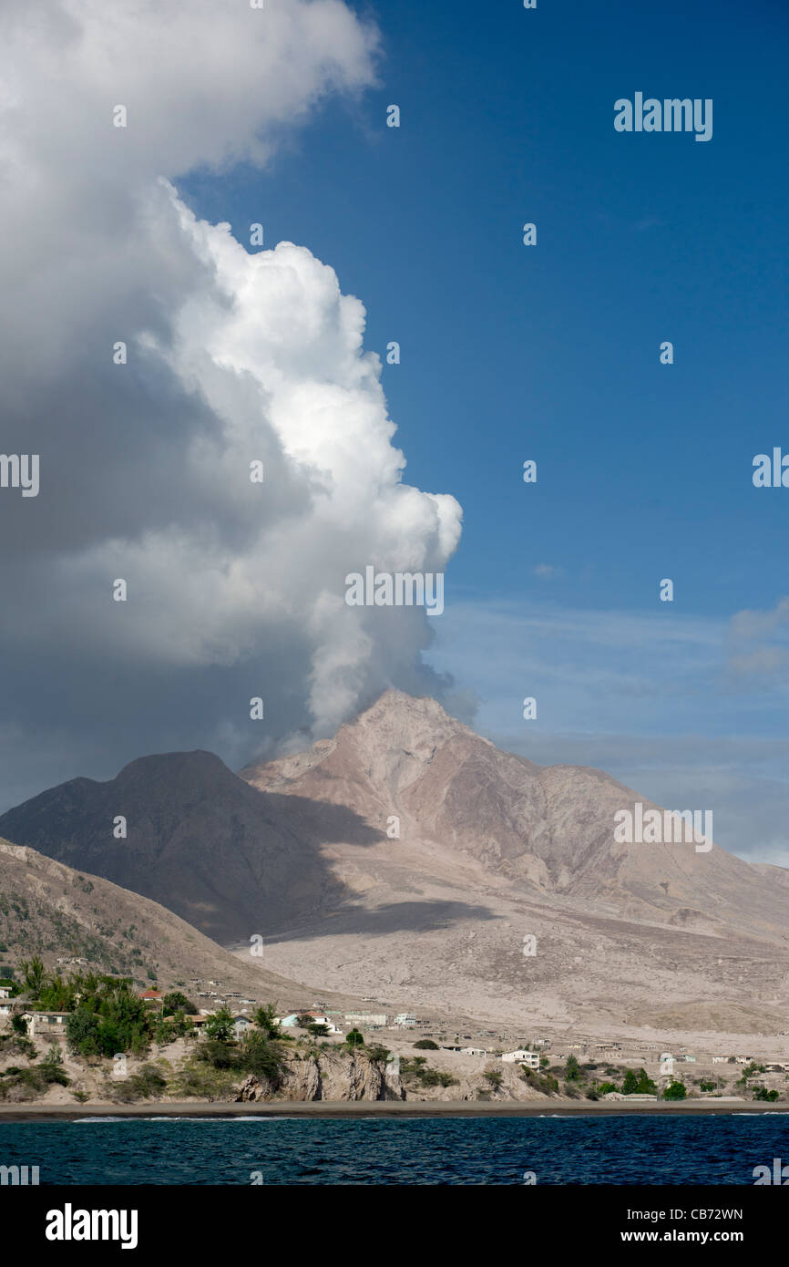 Smoking Soufriere Hills Volcano towering above the ruined former ...