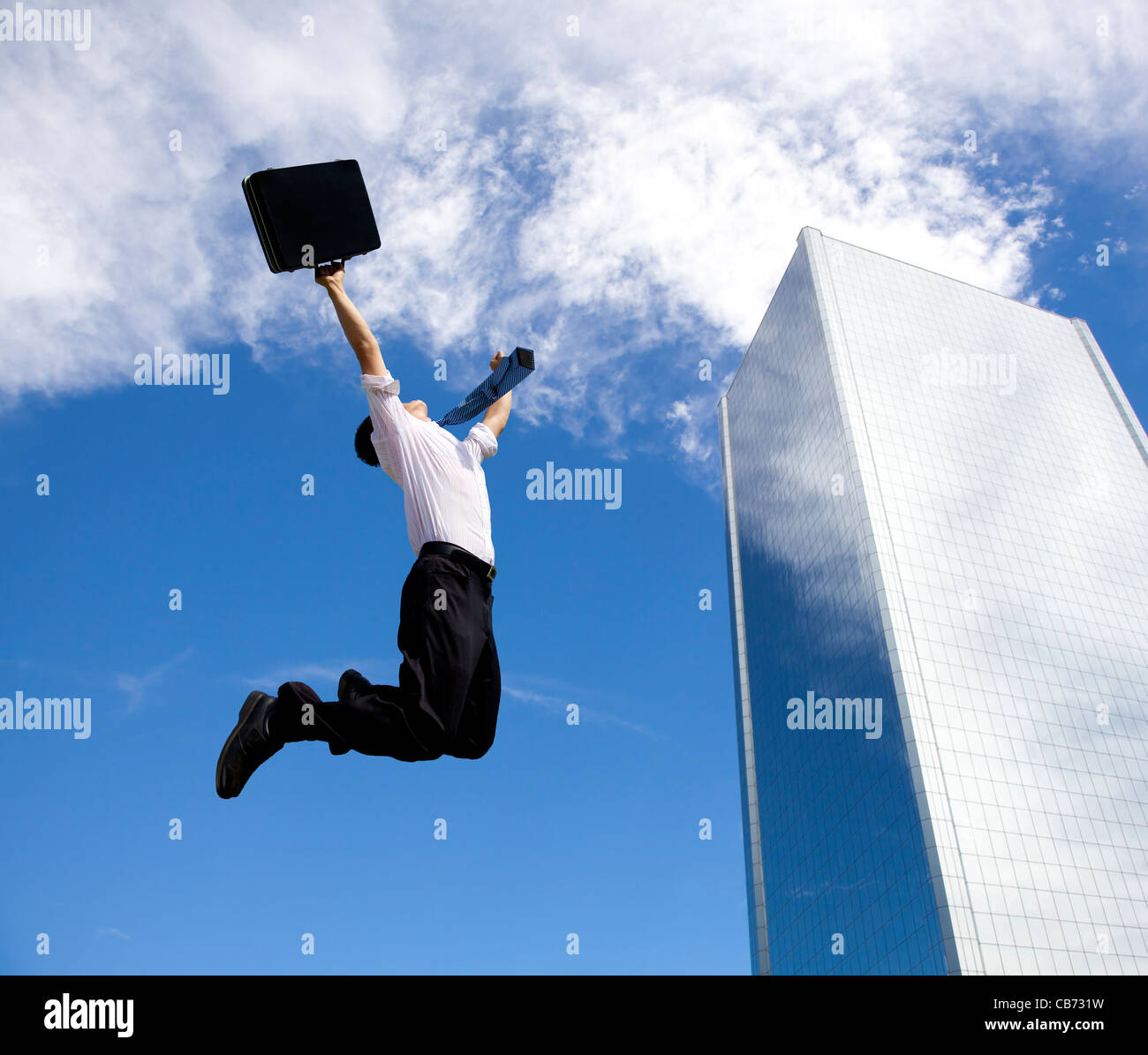 happy businessman jumping in front of a building Stock Photo - Alamy