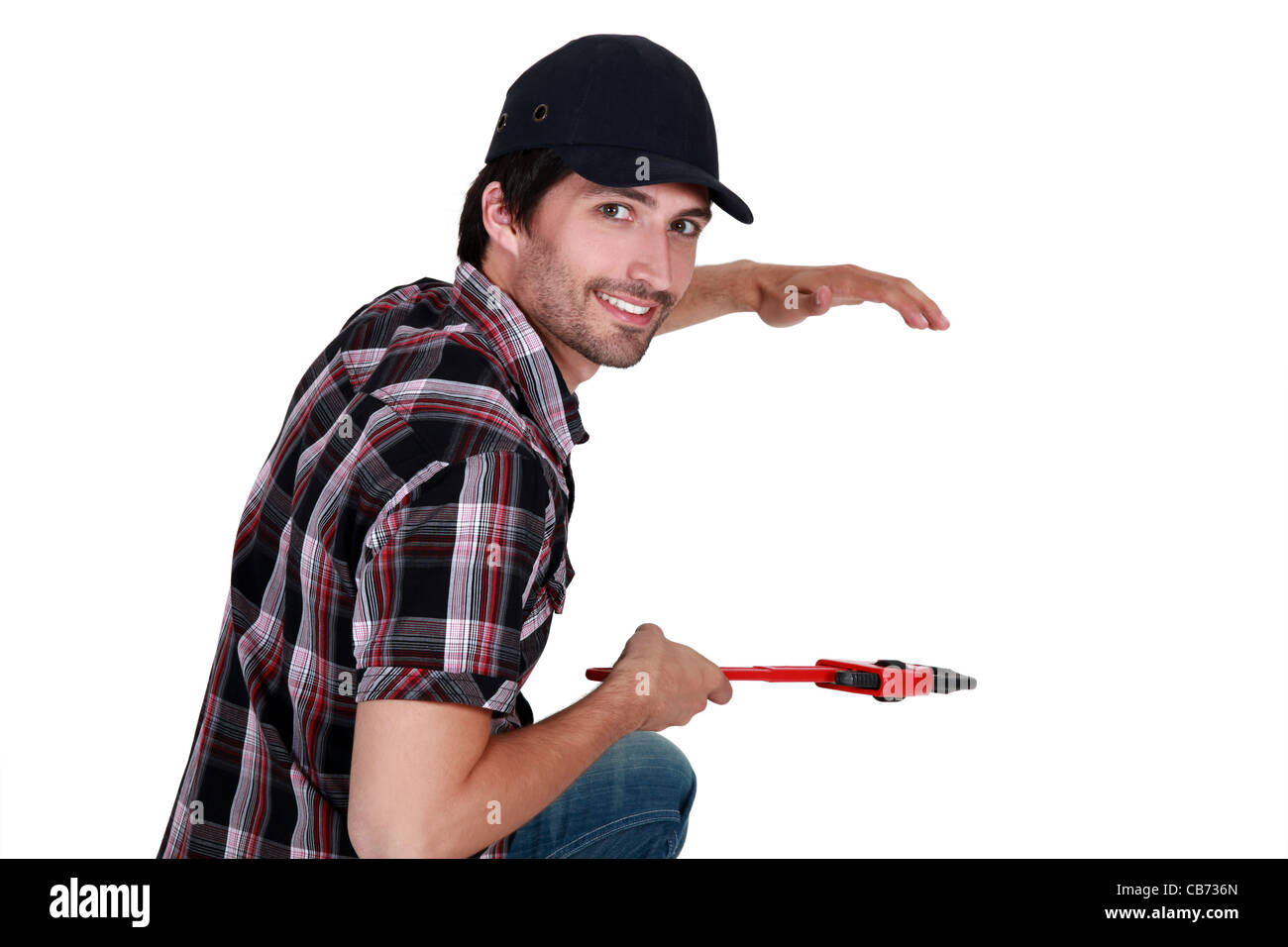 Tradesman fixing an invisible object Stock Photo - Alamy