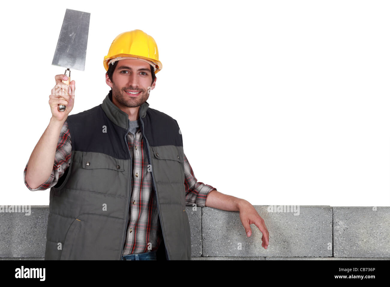 Builder with a bucket trowel and block wall Stock Photo - Alamy
