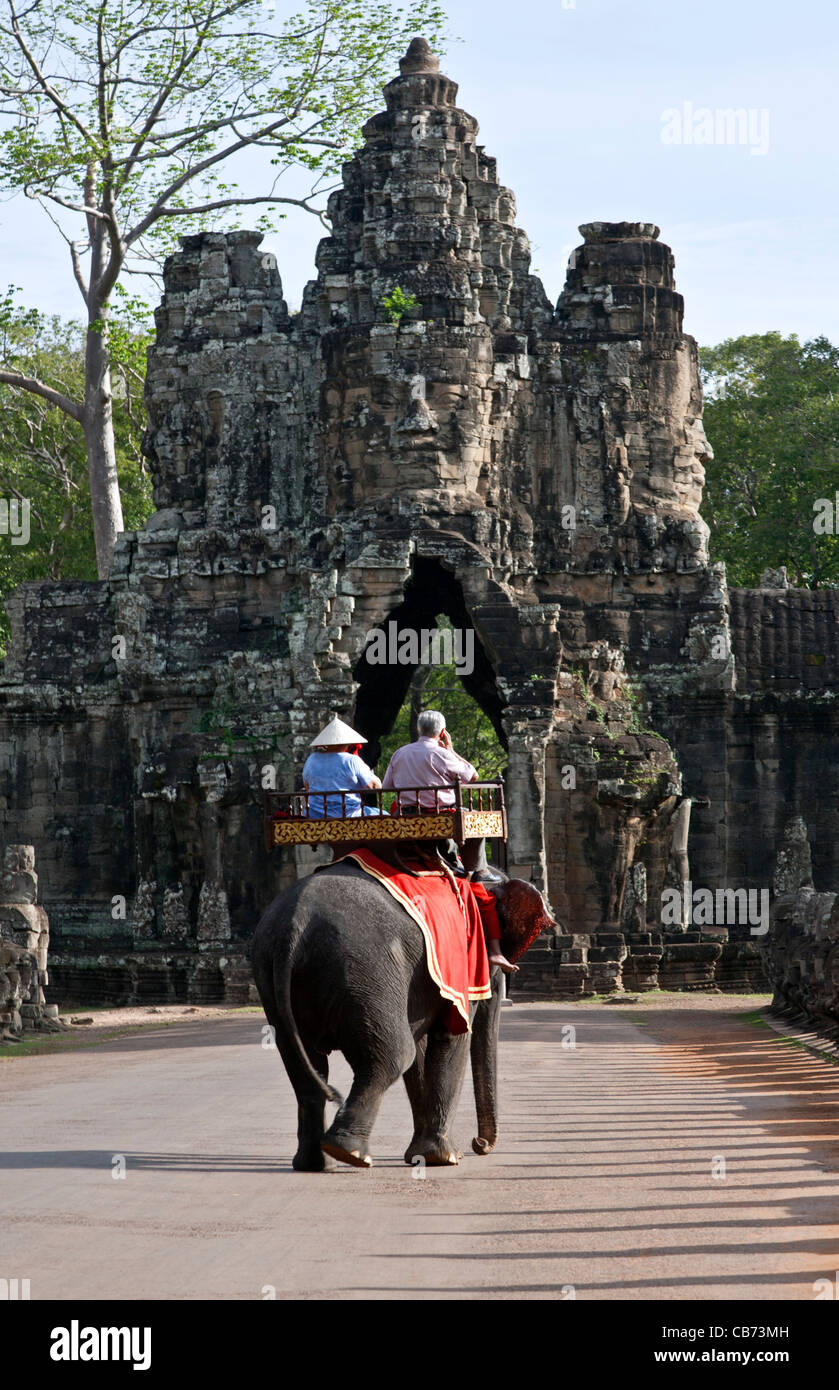 Tourists riding an elephant. Entrance gate to Angkor Thom. Angkor ...