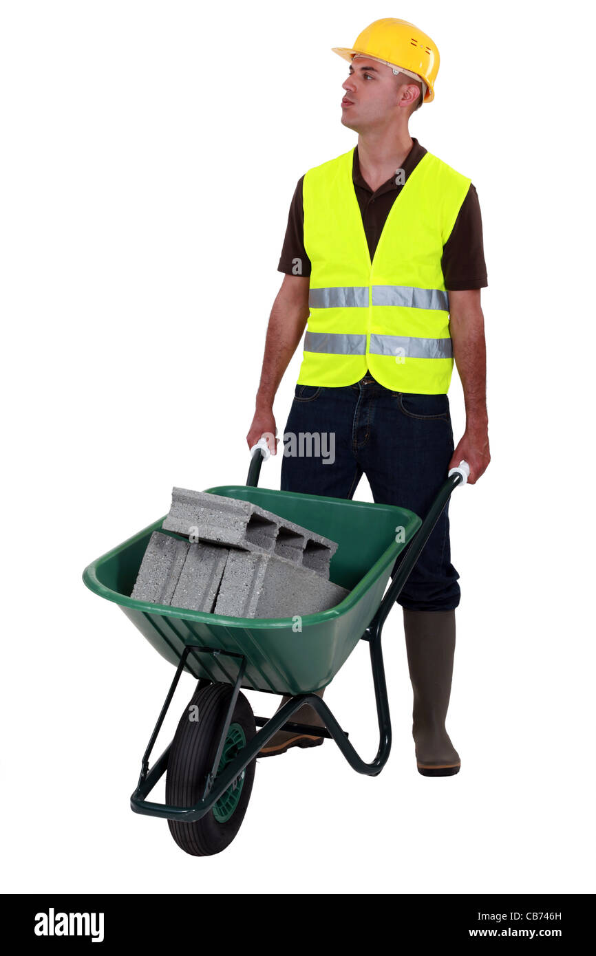 Mason pushing wheelbarrow Stock Photo - Alamy