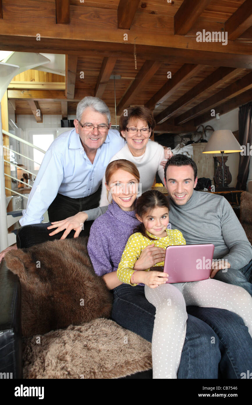 Family gathered around laptop Stock Photo - Alamy