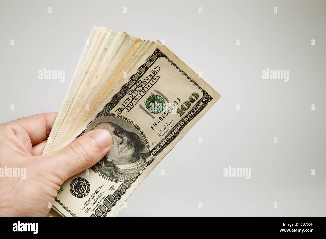 cash concept man holding dollar bills, on grey gradient background ...