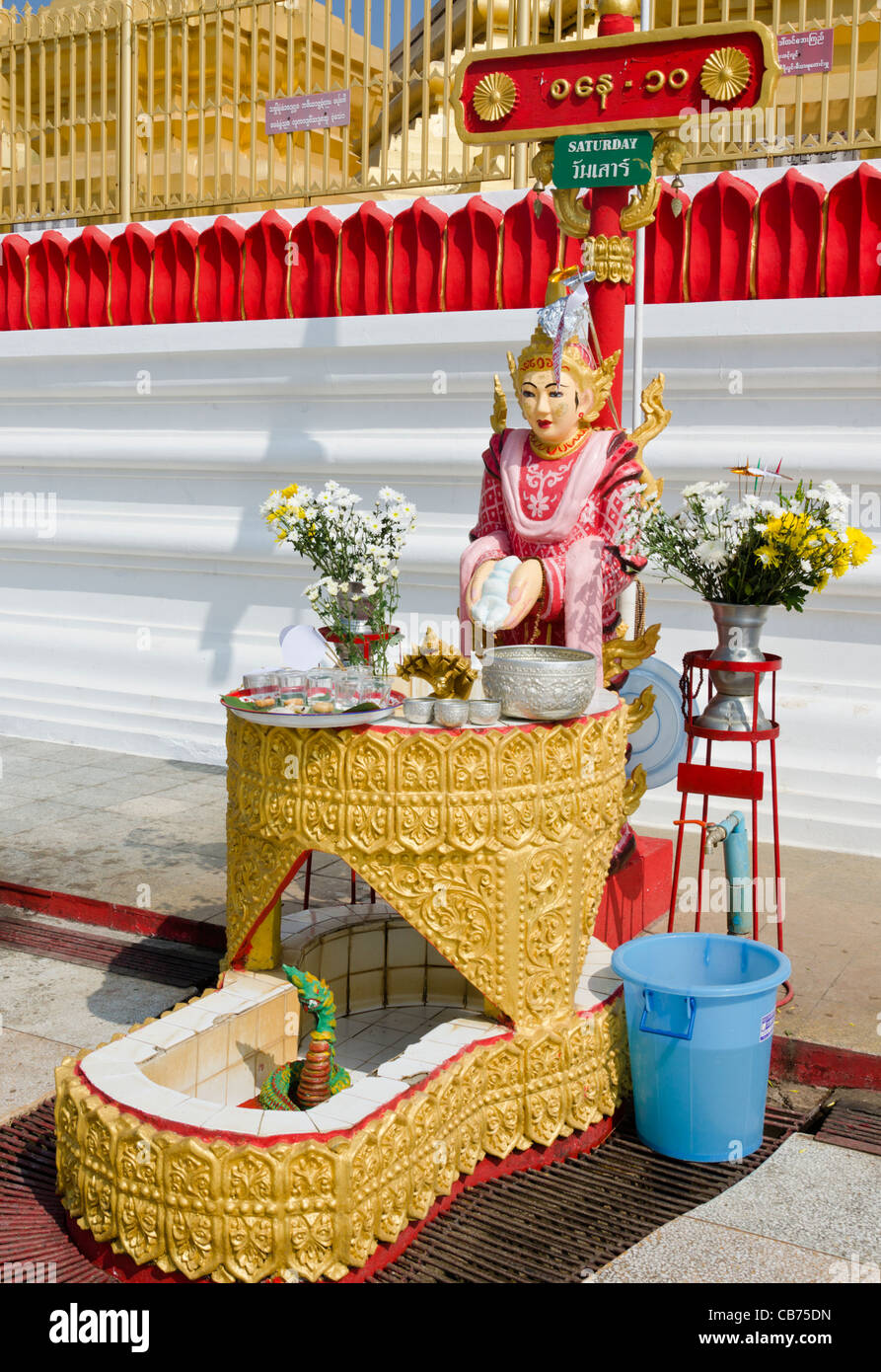 Shrine with flowers & goddess with sign above written in Burmese ...