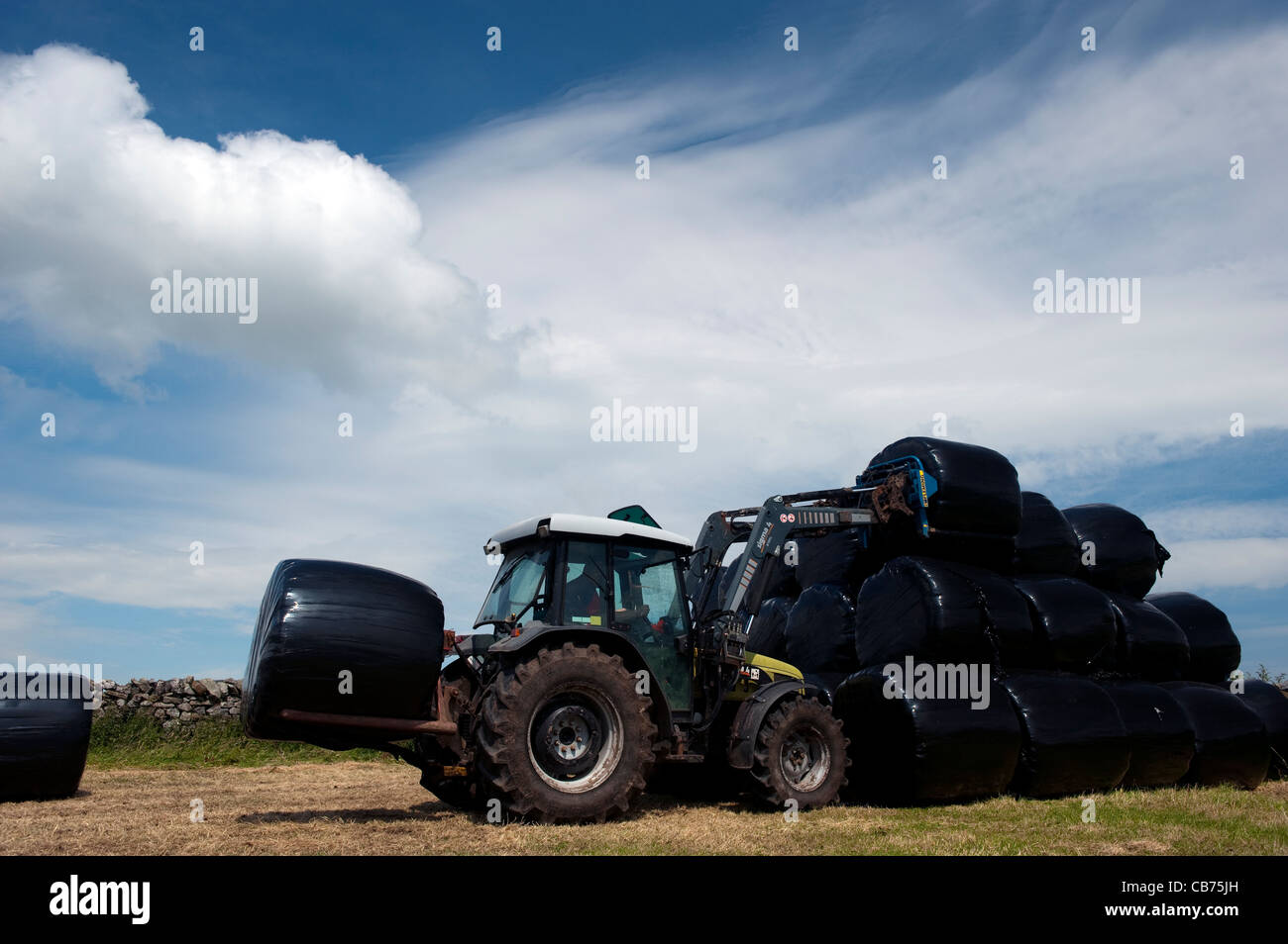 Stacking round bales of silage with Hurlimann tractor and loader Stock ...