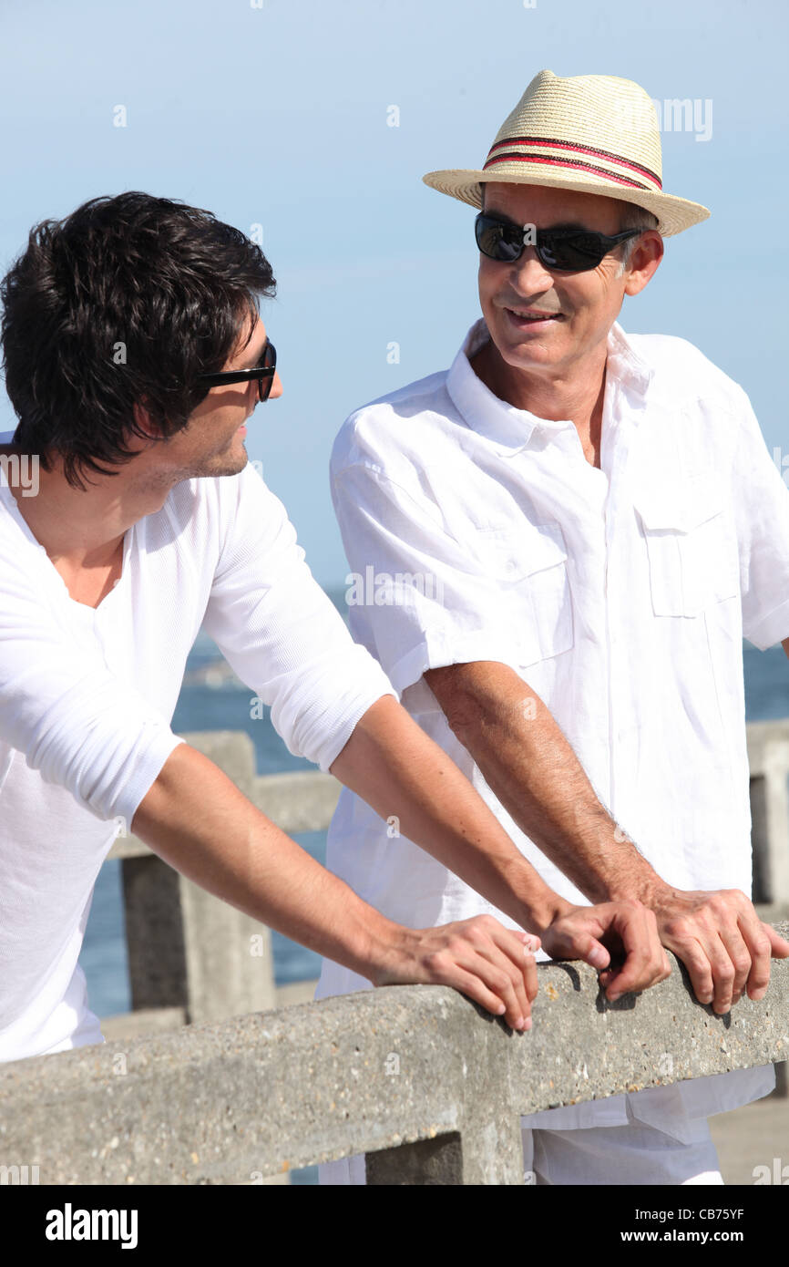 Men standing on a boardwalk Stock Photo - Alamy