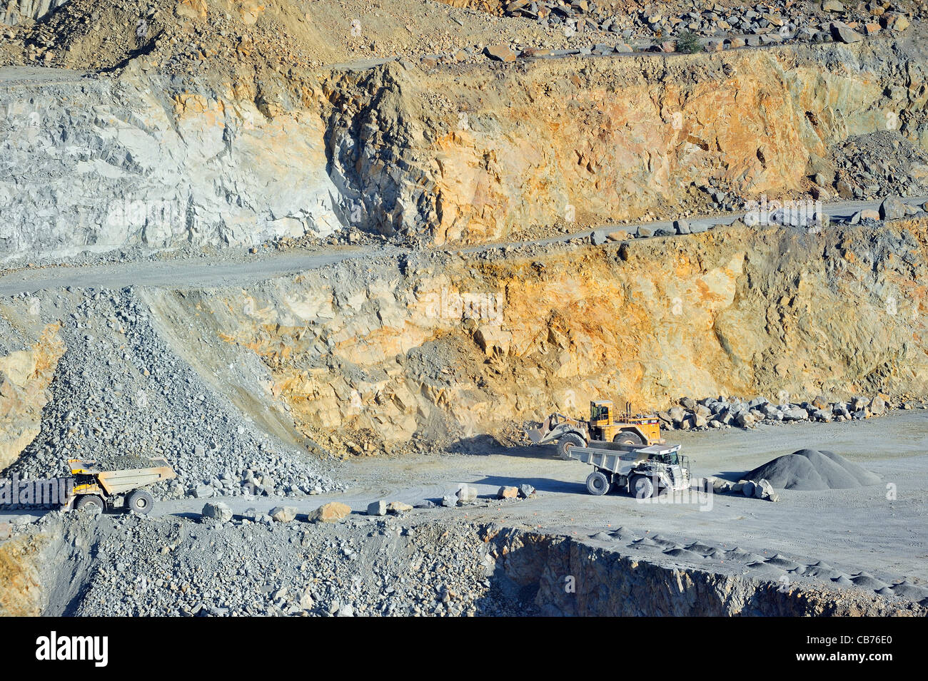 Trucks at work in porphyry quarry, open-pit mine for the production of ...