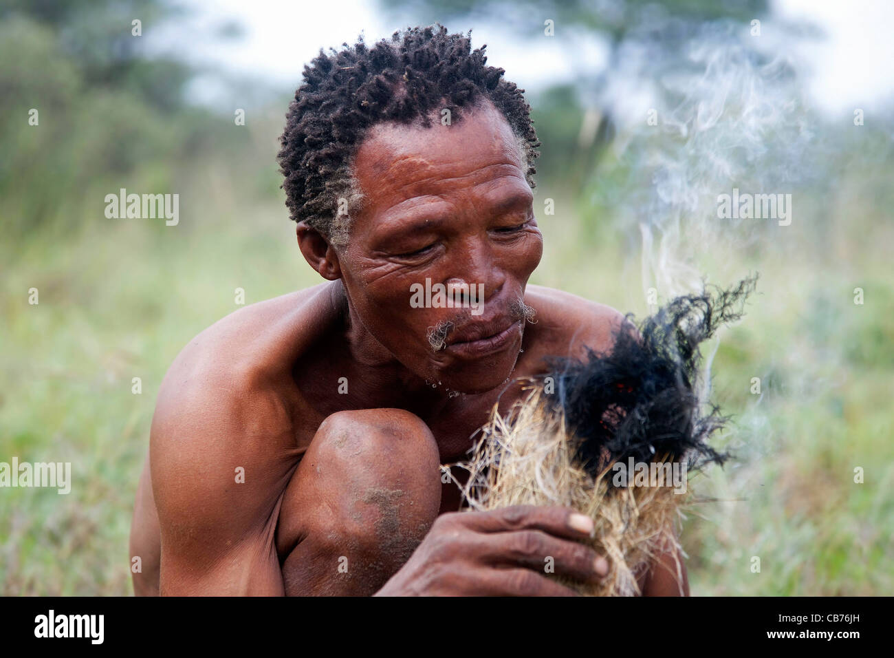 Bushman starting fire in the Kalahari desert near Ghanzi, Botswana ...