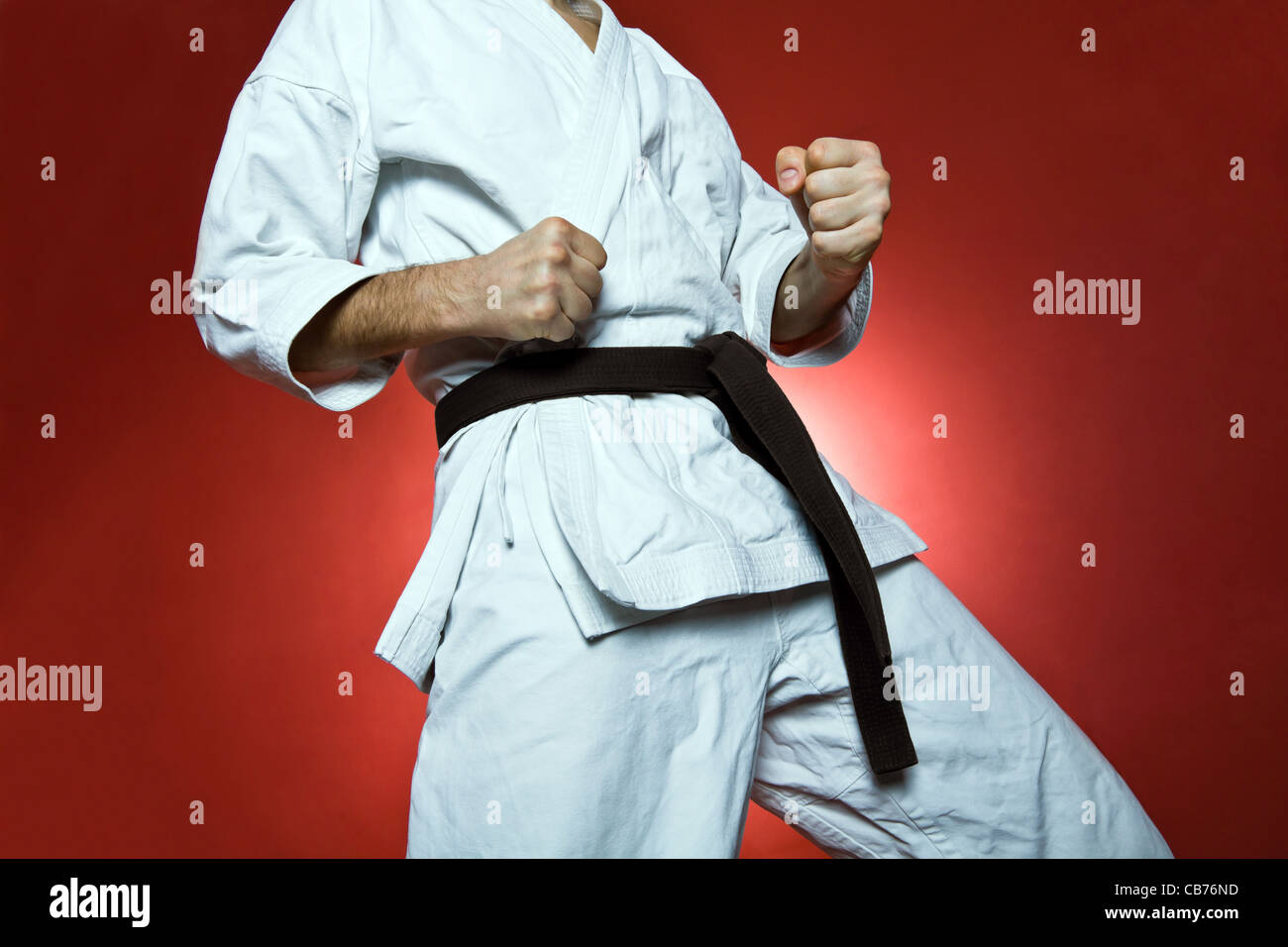 Young man practicing karate over red background Stock Photo - Alamy