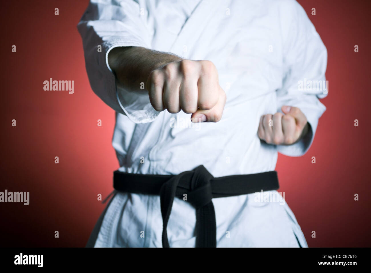 Young man practicing karate over red background Stock Photo - Alamy