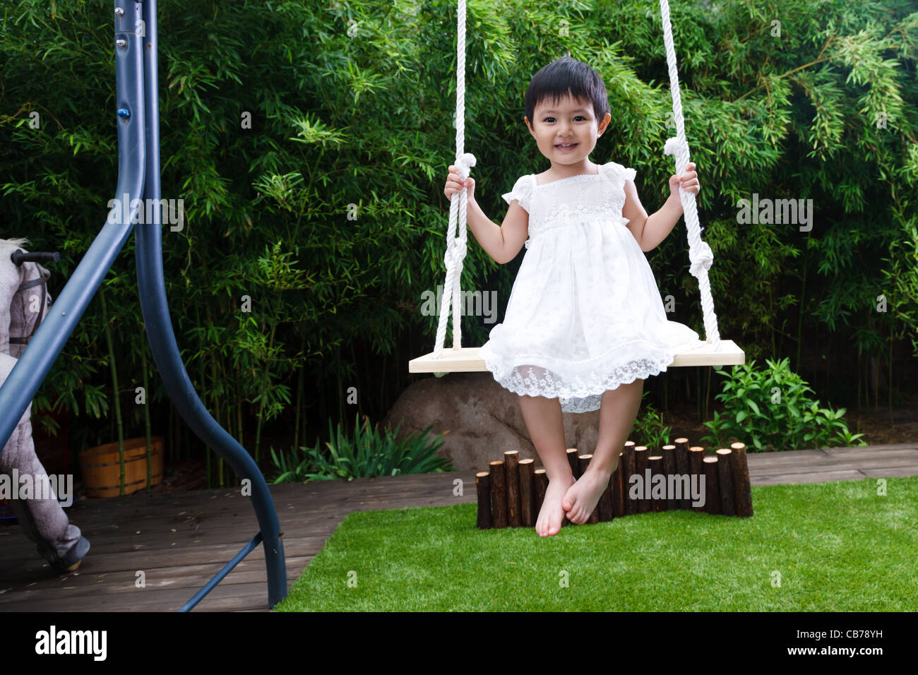 Girl sitting on swing Stock Photo - Alamy