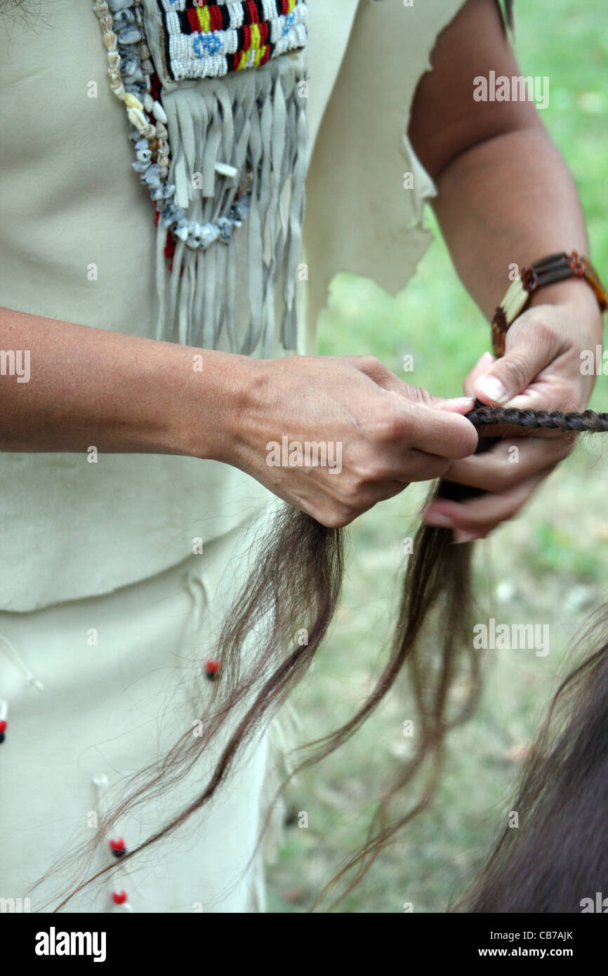 A Native American Indian woman braiding a childs hair Stock Photo - Alamy