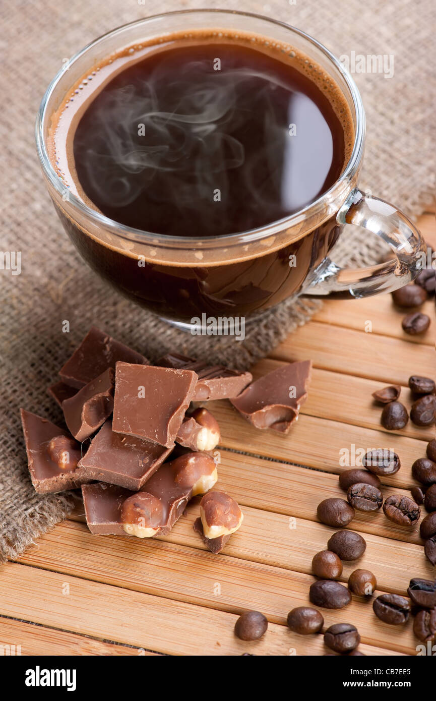 Cup of coffee, chocolate with nuts and coffee beans on wooden ...