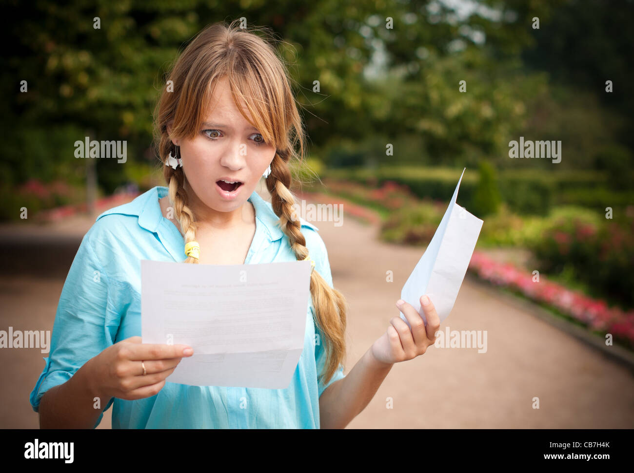 beautiful young student girl shocked by message she is reading. She is ...