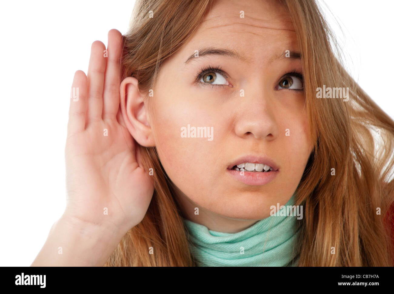beautiful teenage girl, with hand at her ear, hearing something ...