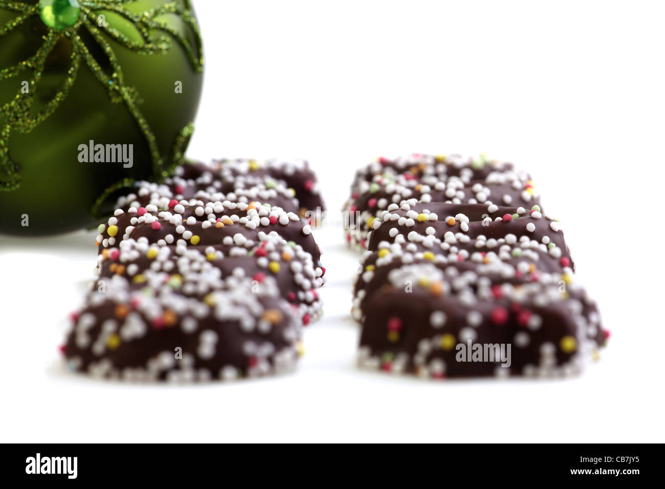 Many Sugar curls and a green christmas bauble isolated on white ...