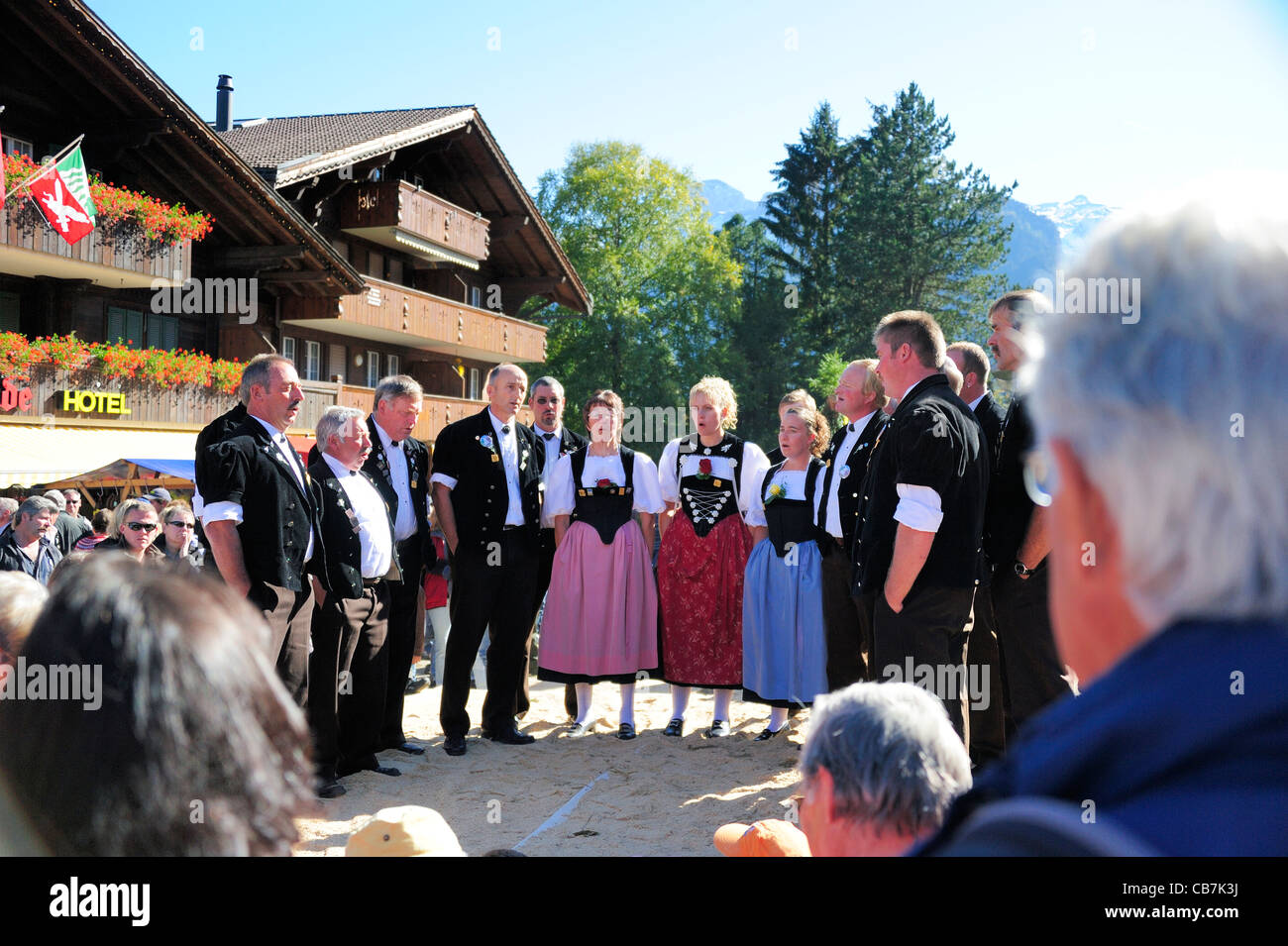 A group of Swiss yodelers, in full song, watched by an audience, with ...