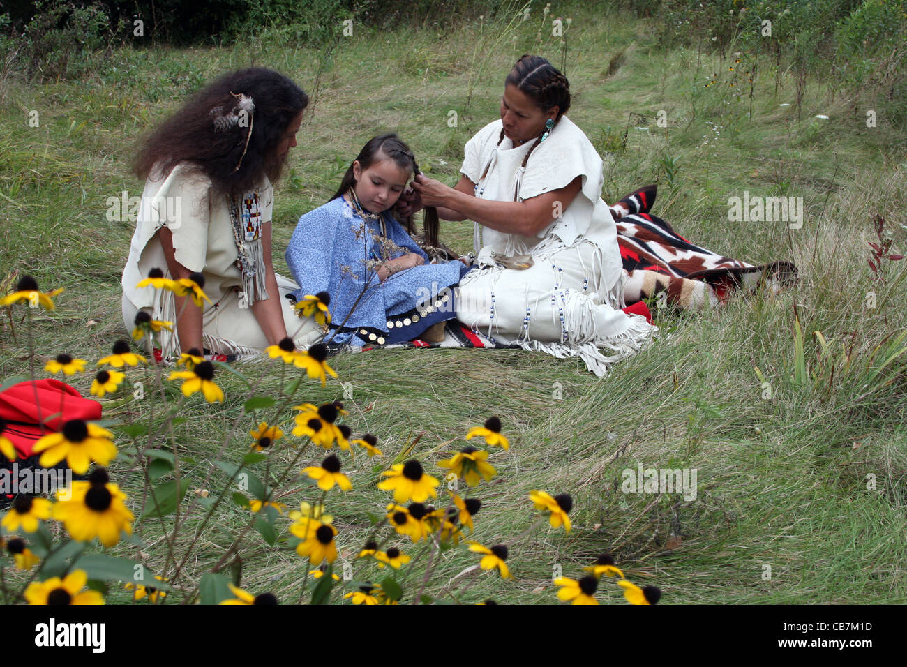 A group of Native American Indian Lokota Sioux women braiding hair of a ...