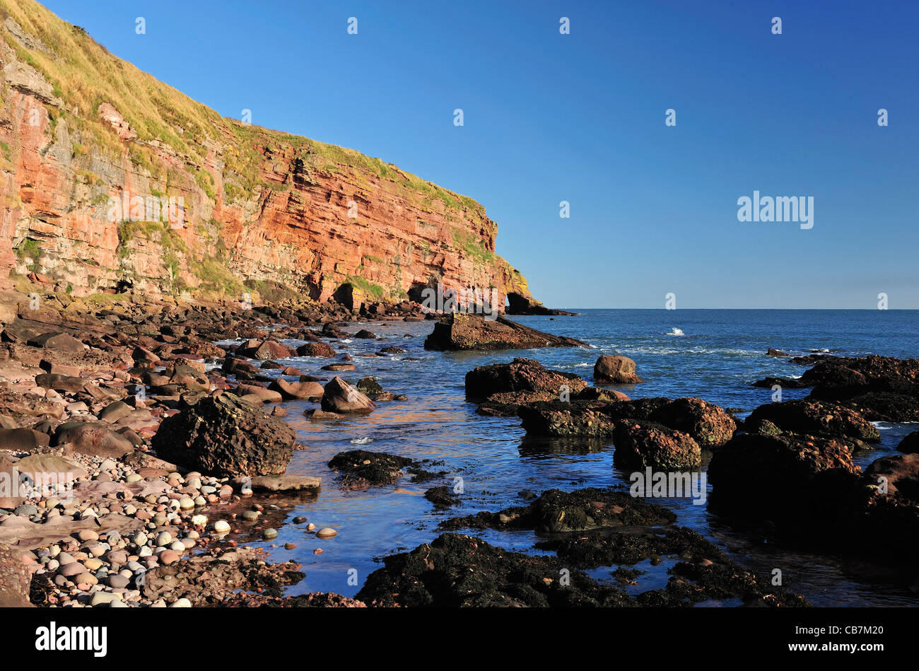 Coastal scene of red sandstone cliffs at Auchmithie, Angus, Scotland ...