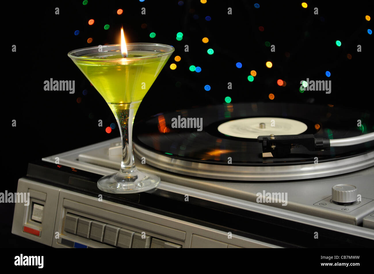 Spinning turntable with a fancy wineglass candle against colorful ...