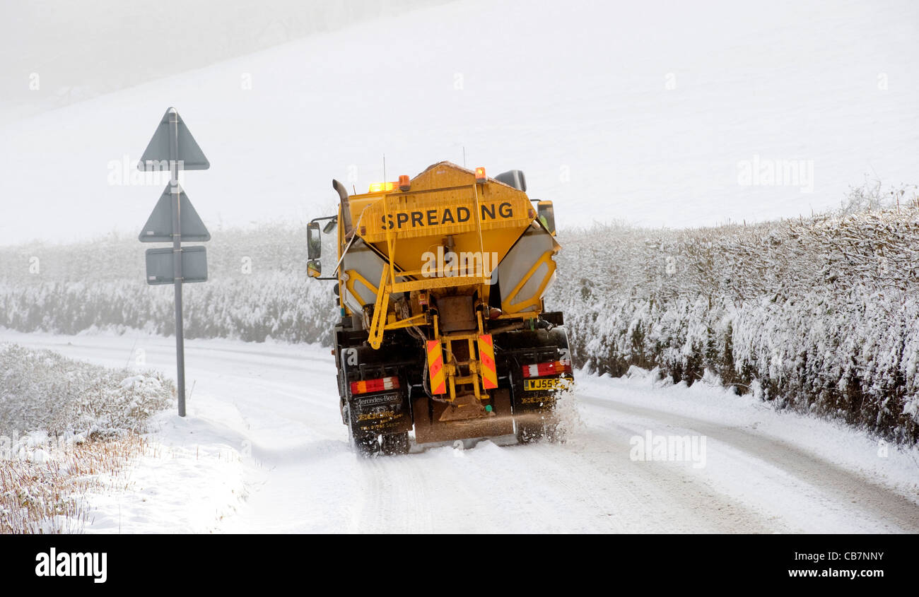 A yellow snow plow grits roads in North Devon as snow covers the ...