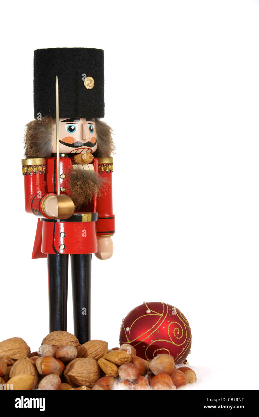 Traditional nutcracker with nuts and christmas tree ball on white ...