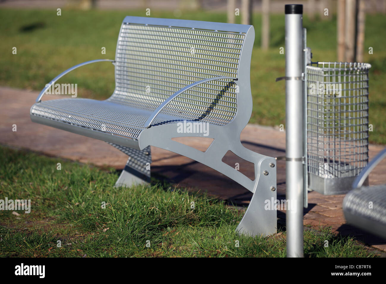 Park bench and a trash can in a public park Stock Photo - Alamy