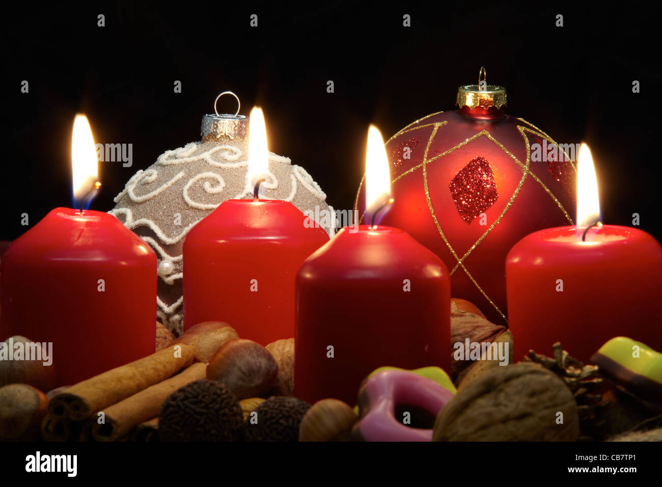 Advent wreath with four burning candles and tow christmas tree balls in ...