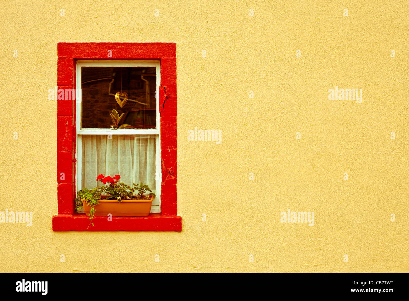 vibrant red window frame in a yellow wall Stock Photo - Alamy