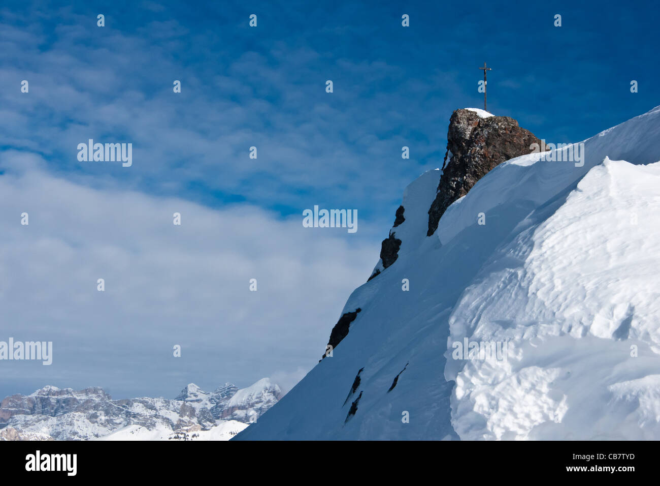 A cross marking the top of snow covered peak of Passo Padon in ski ...