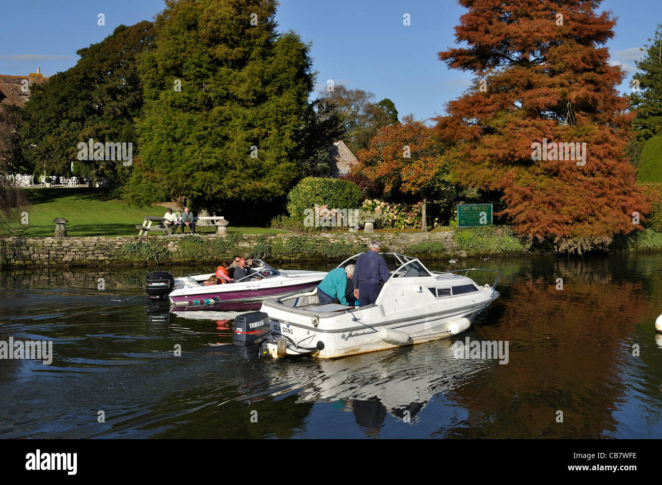 Two motor boats cruise on the River Frome, past the grounds of the ...