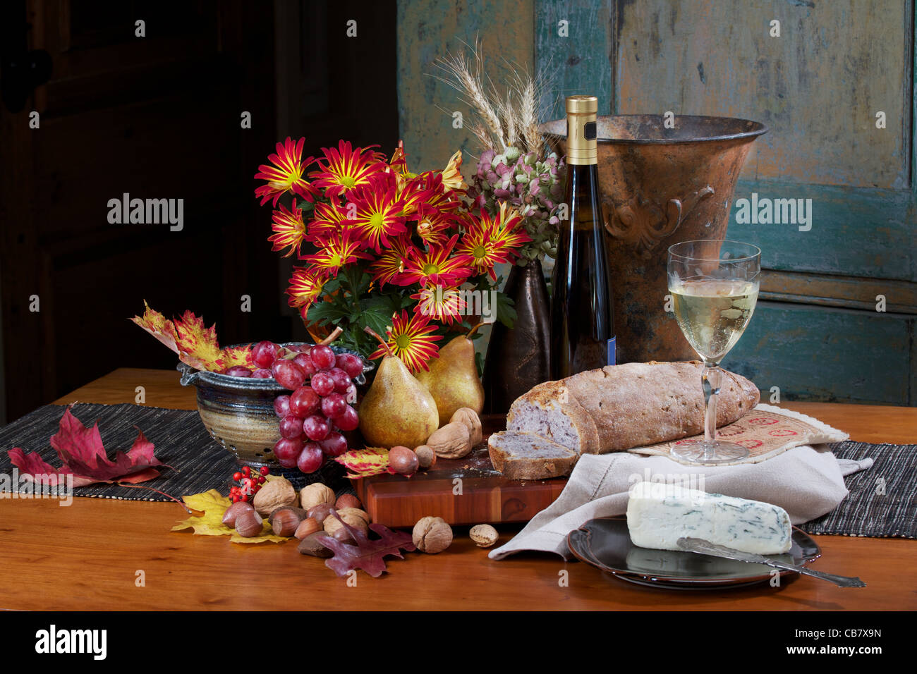 Elegant French country style still life with wine, cheese, bread, fruit ...