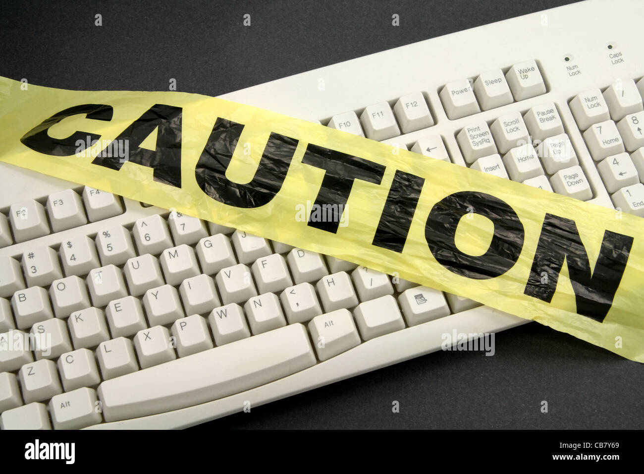 plastic caution tape and keyboard, computer crime Stock Photo - Alamy