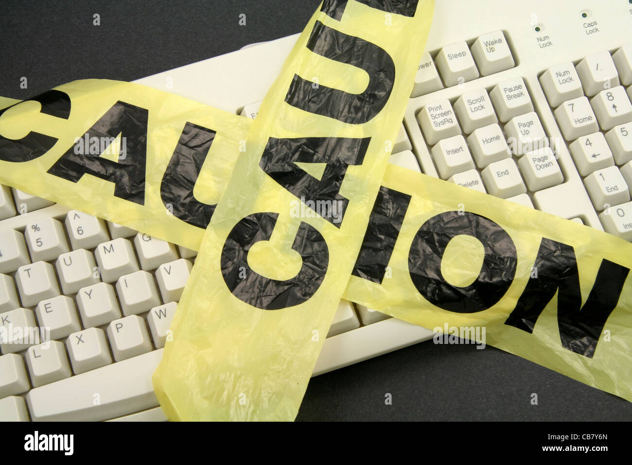 plastic caution tape and keyboard, computer crime Stock Photo - Alamy