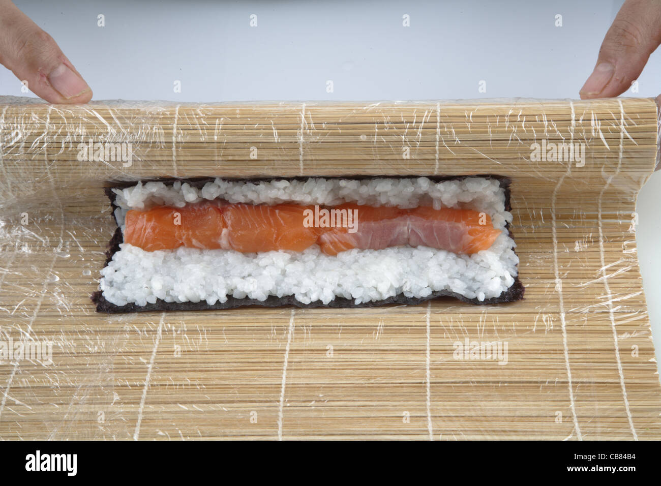 Wrapping a salmon sushi Stock Photo - Alamy