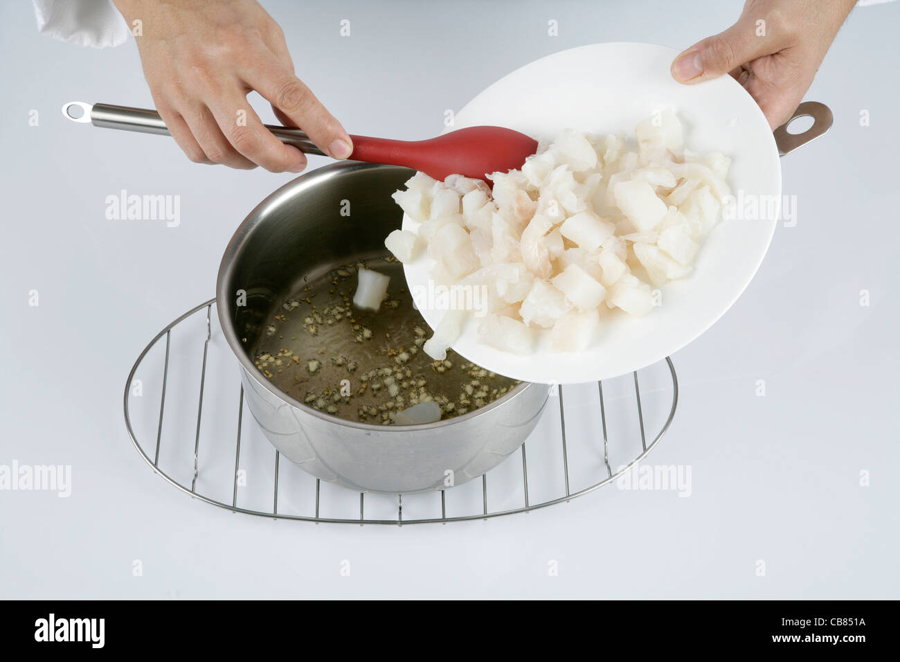 Adding shredded cod Stock Photo - Alamy
