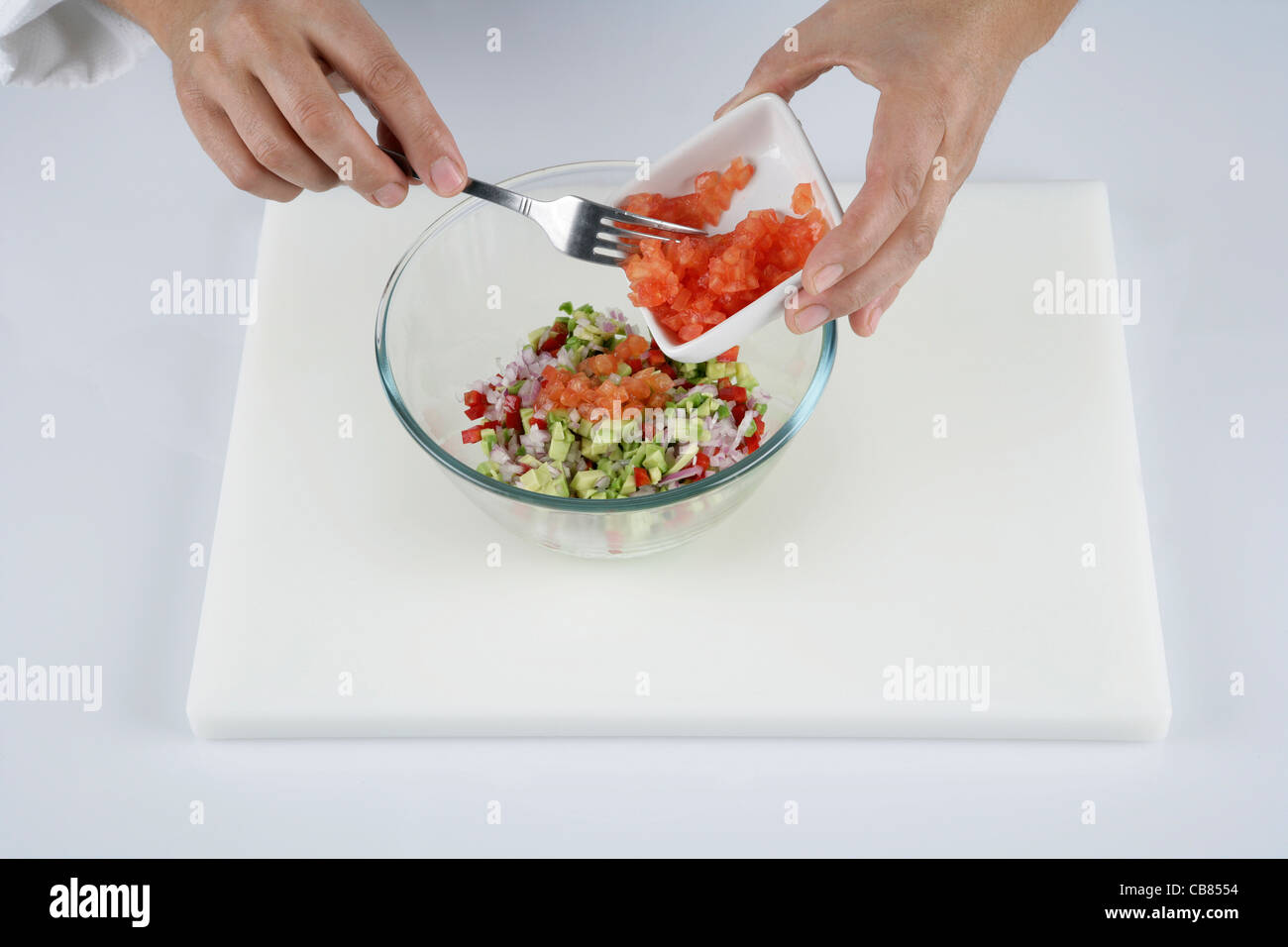 Adding chopped tomatoes Stock Photo - Alamy