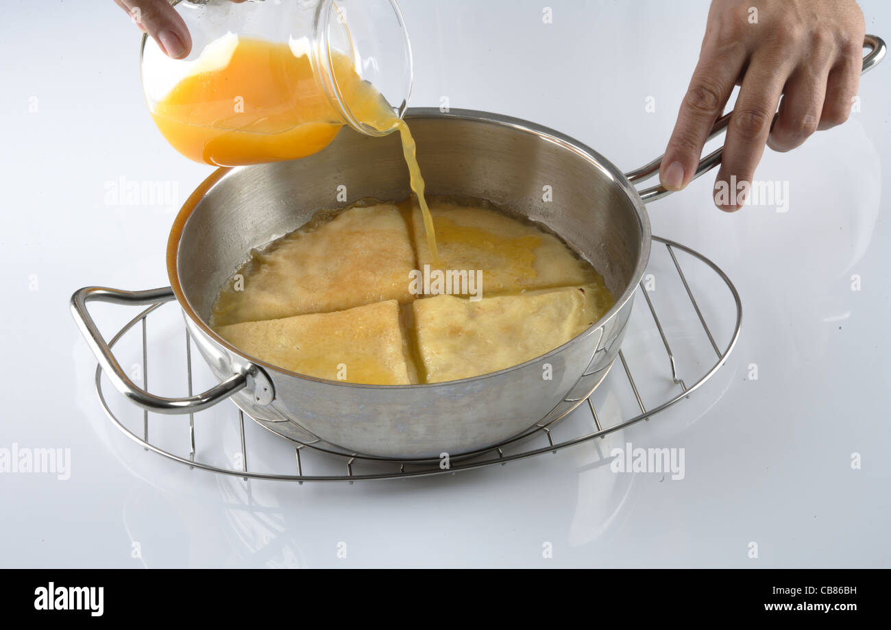 Adding orange juice over crepes Stock Photo - Alamy