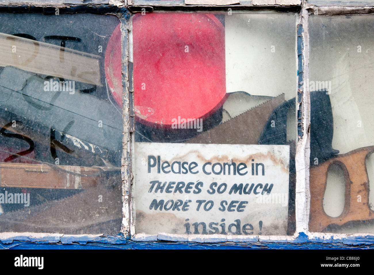 Dirty shop window with sign saying "please come in there's so much more ...