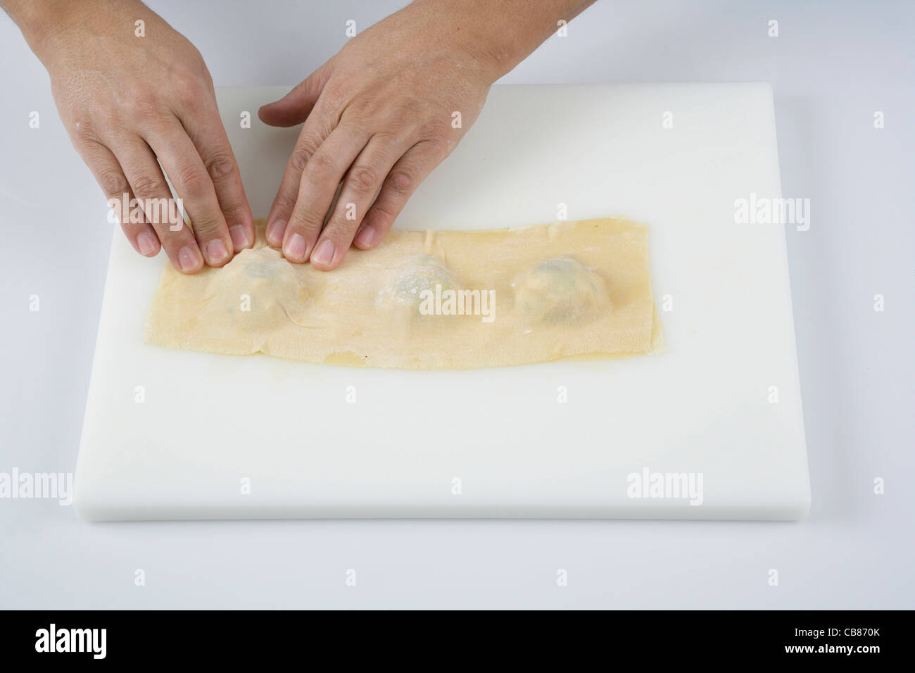Pressing pasta to seal ravioli Stock Photo - Alamy