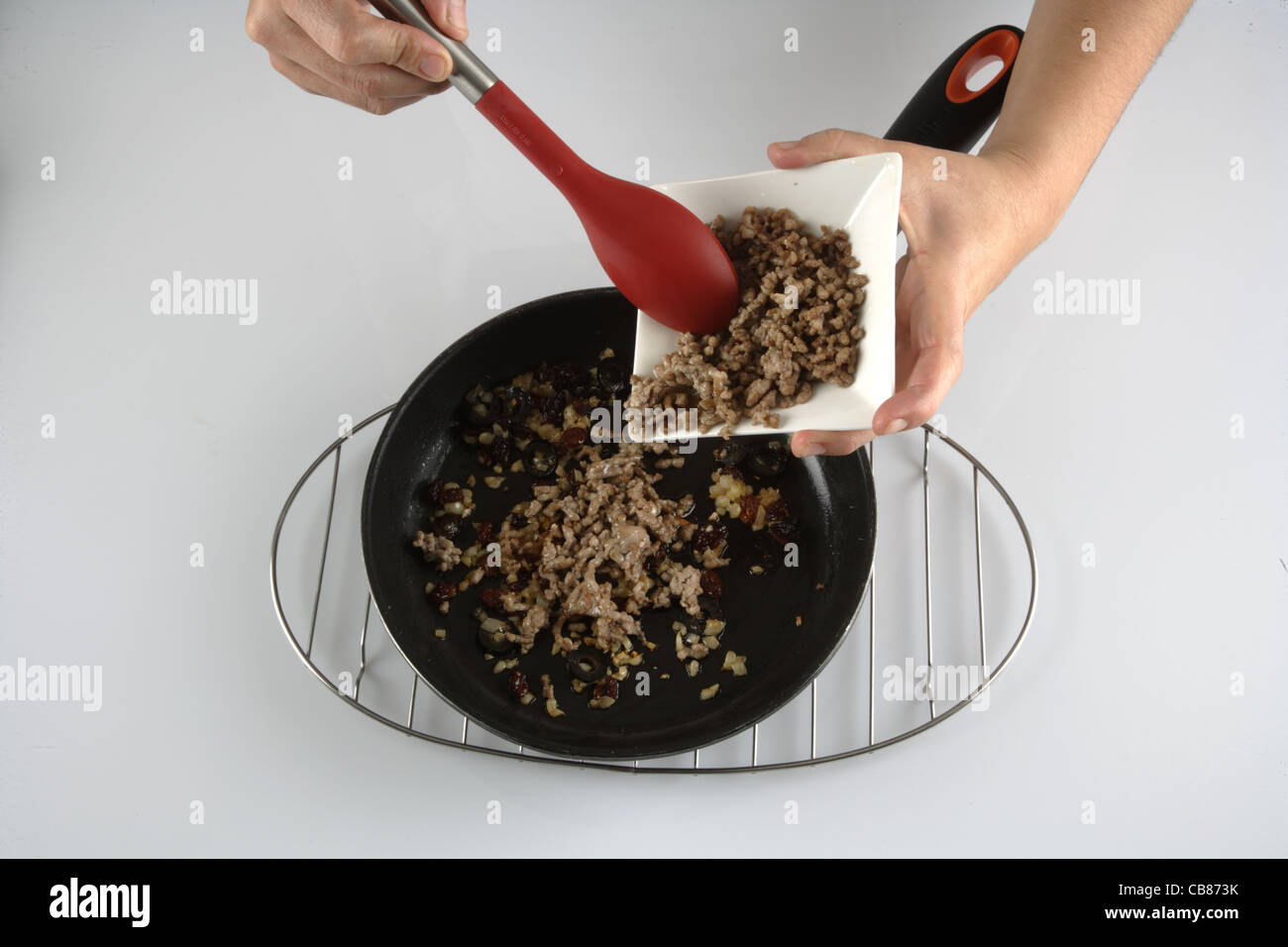Adding sauteed meat Stock Photo - Alamy